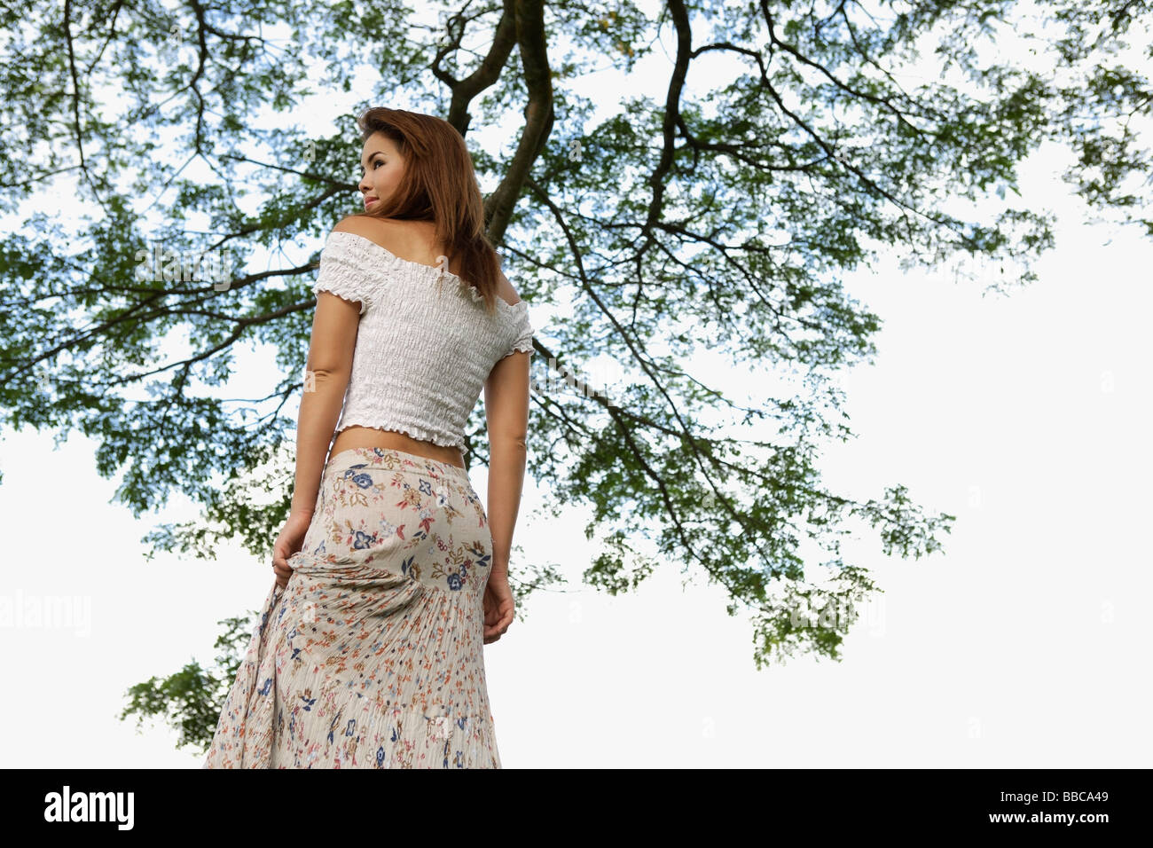 Woman standing under tree Stock Photo - Alamy