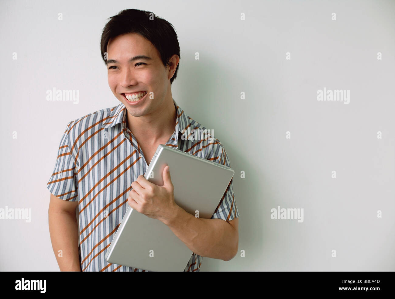 Man holding laptop, smiling Stock Photo - Alamy