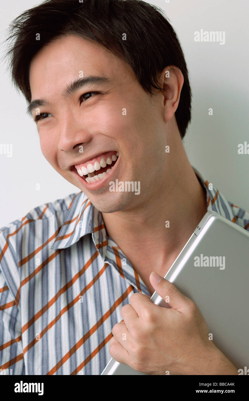 Man holding laptop, smiling Stock Photo - Alamy
