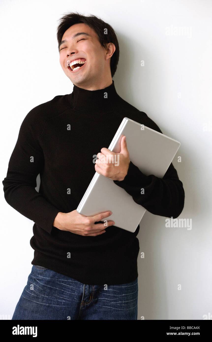 Man hugging laptop, laughing Stock Photo - Alamy