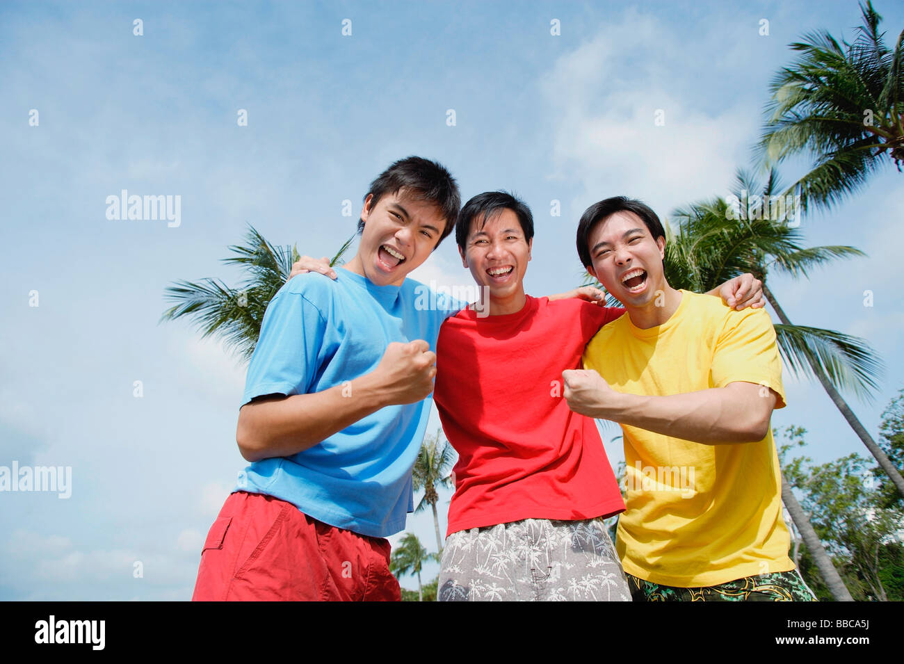 Three men with arms around each other, looking at camera Stock Photo ...