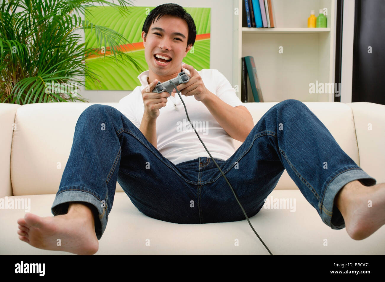 Man playing with video game at home Stock Photo - Alamy