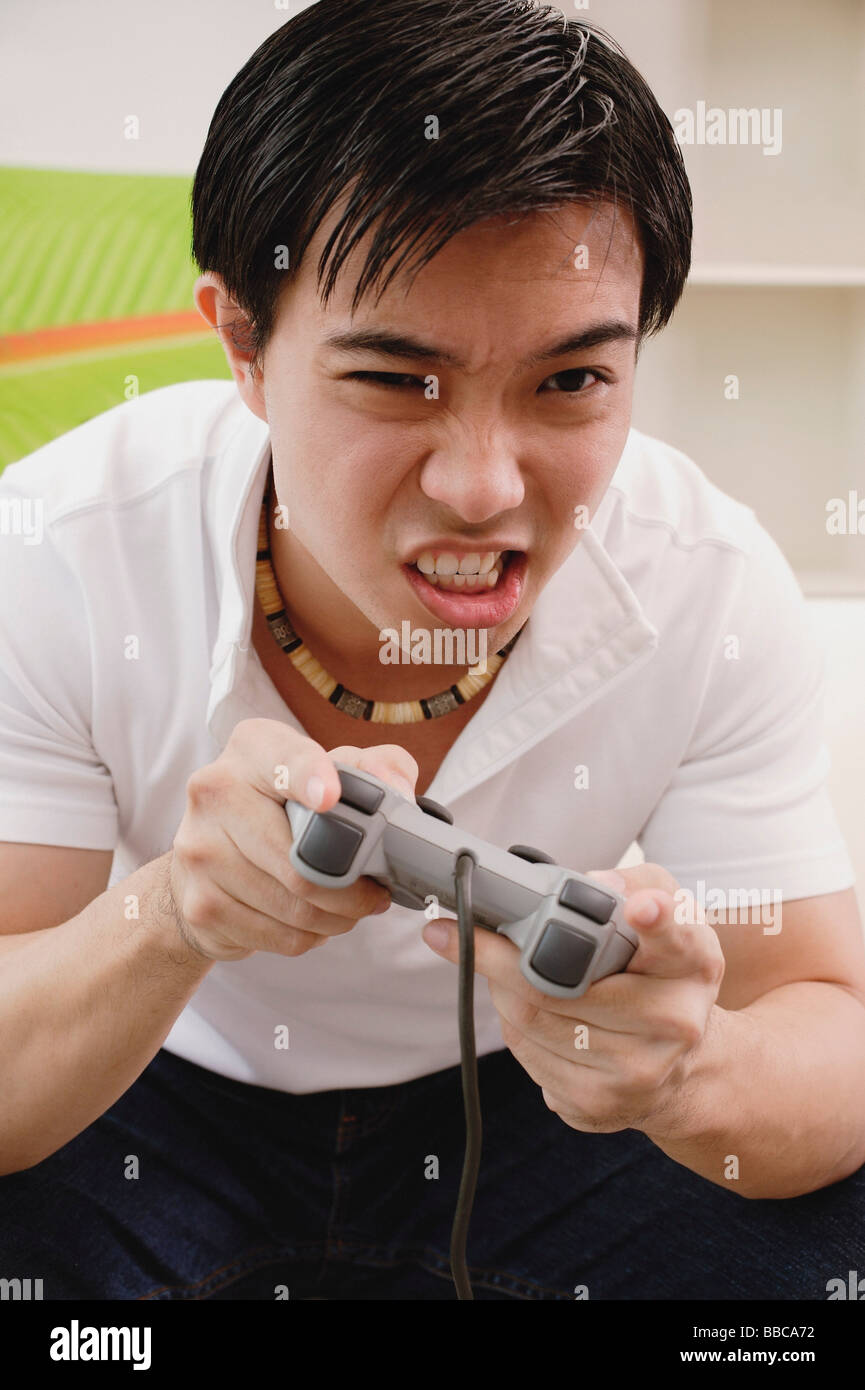 Man holding video game console, grimacing Stock Photo - Alamy