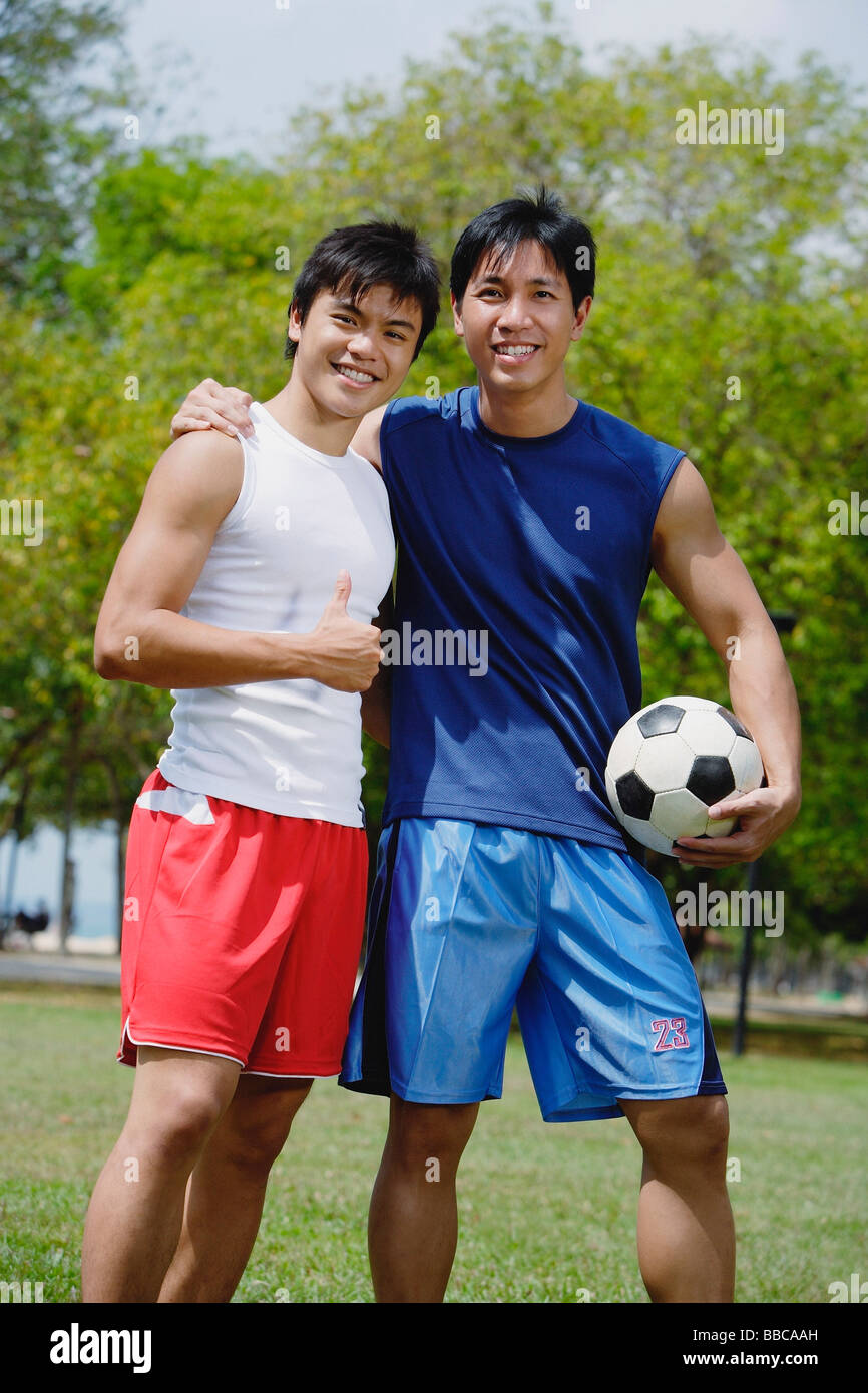 Two men looking at camera, one holding soccer ball Stock Photo - Alamy