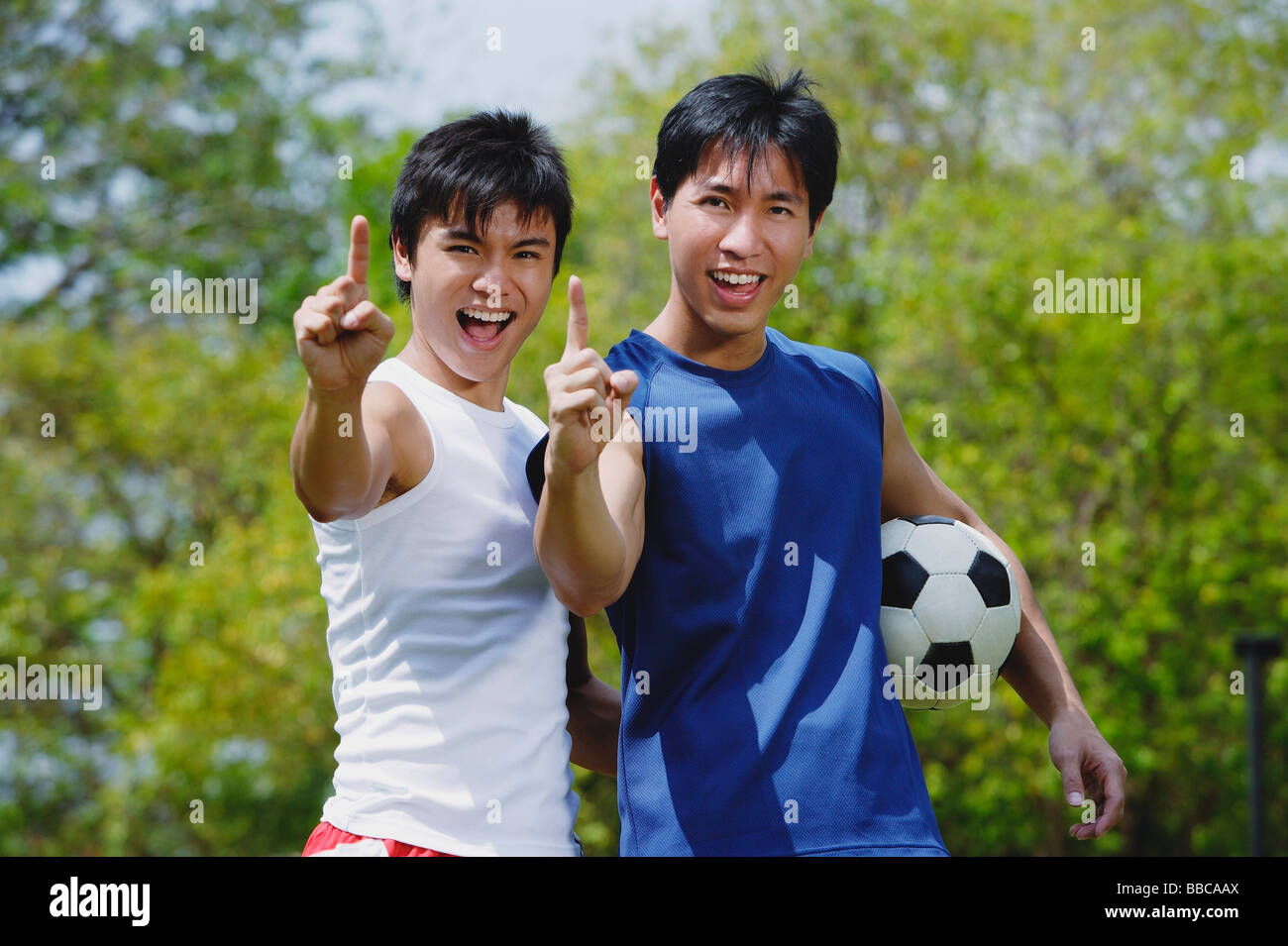 Two men looking at camera, making hand sign Stock Photo - Alamy