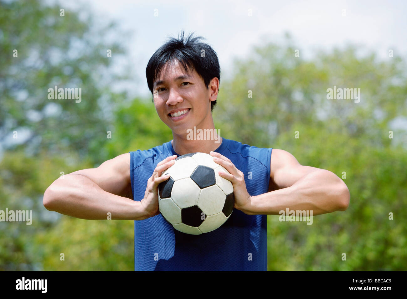 Man holding soccer ball in both hands Stock Photo - Alamy
