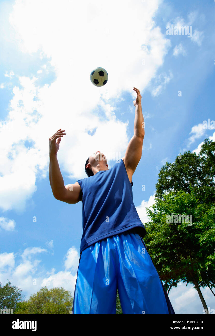 Man looking up at soccer ball Stock Photo - Alamy
