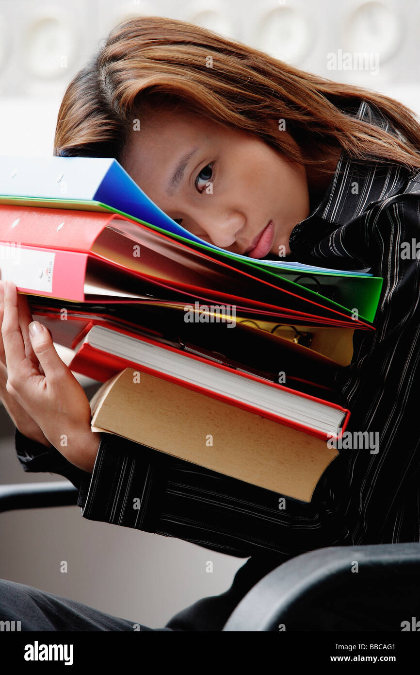 Female executive leaning on stack of binders Stock Photo - Alamy