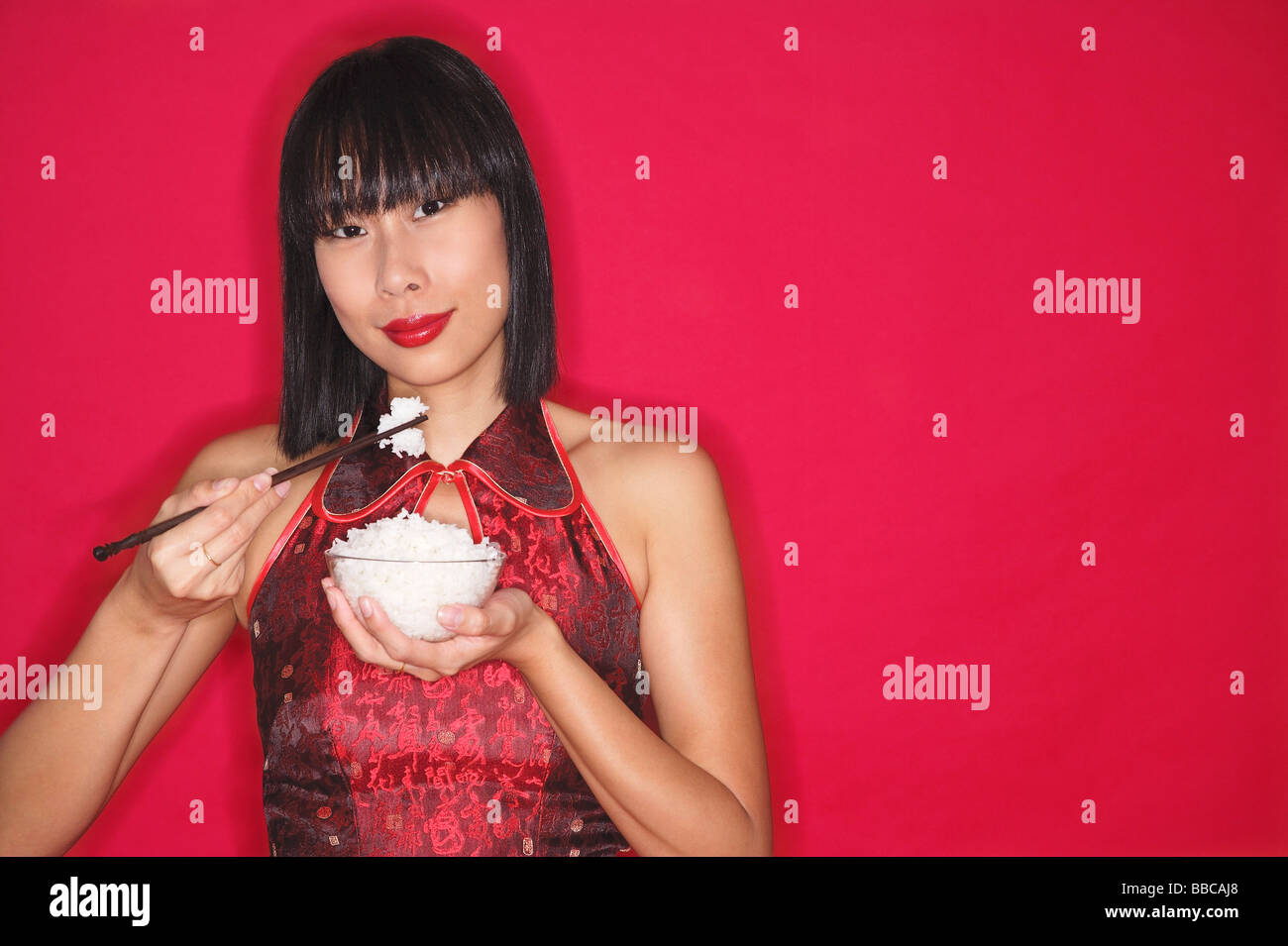 Woman in cheongsam holding bowl of rice Stock Photo - Alamy