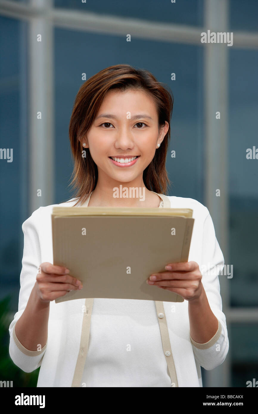 Female executive holding folders towards camera Stock Photo - Alamy