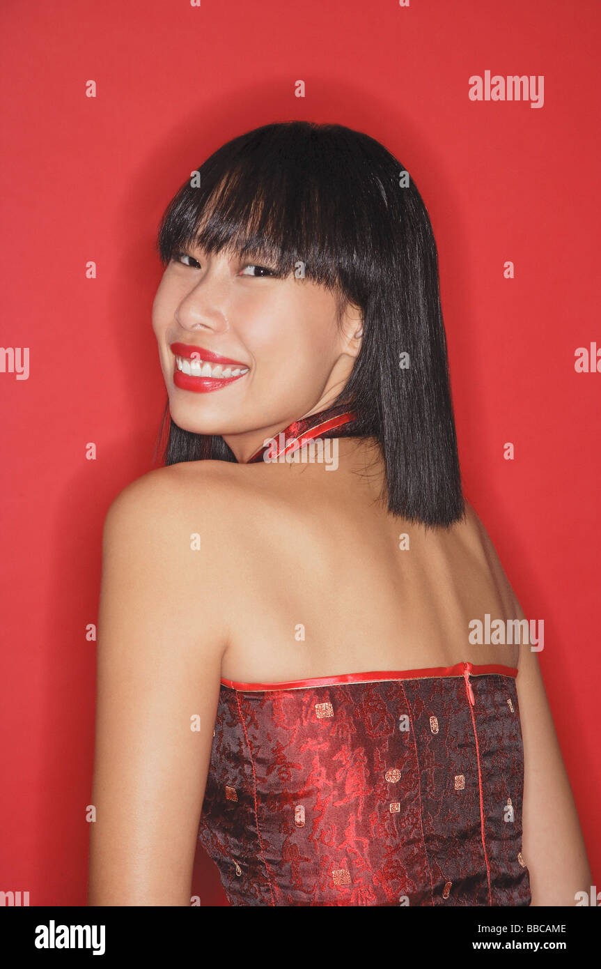 Woman against red background, looking over shoulder, smiling Stock ...