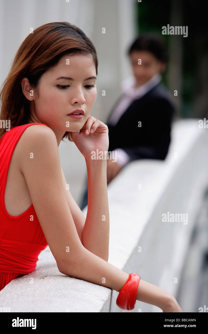 Woman leaning over bridge railing, looking down Stock Photo - Alamy