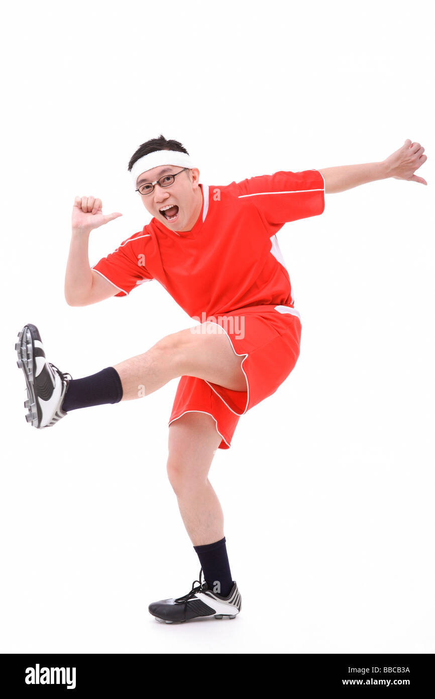 Man in soccer uniform, kicking leg in air Stock Photo - Alamy