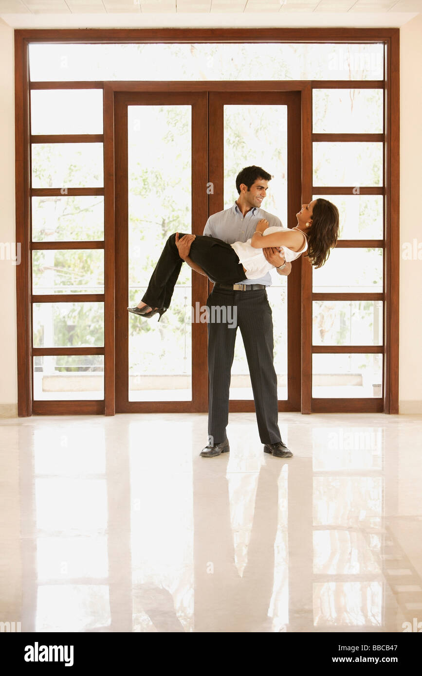 man carrying woman over threshold into empty home Stock Photo - Alamy