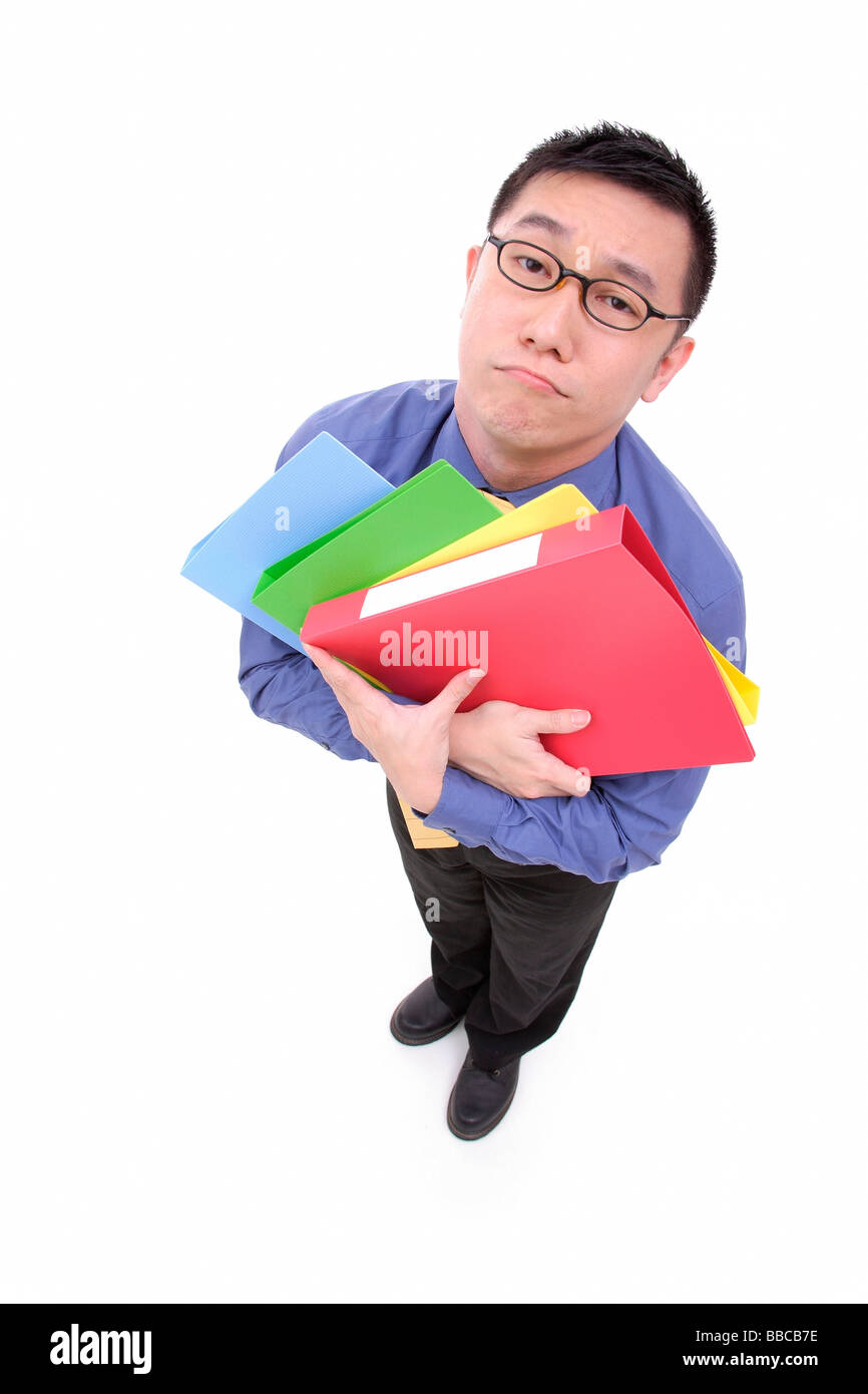 Businessman carrying multi coloured folders, sad expression Stock Photo ...