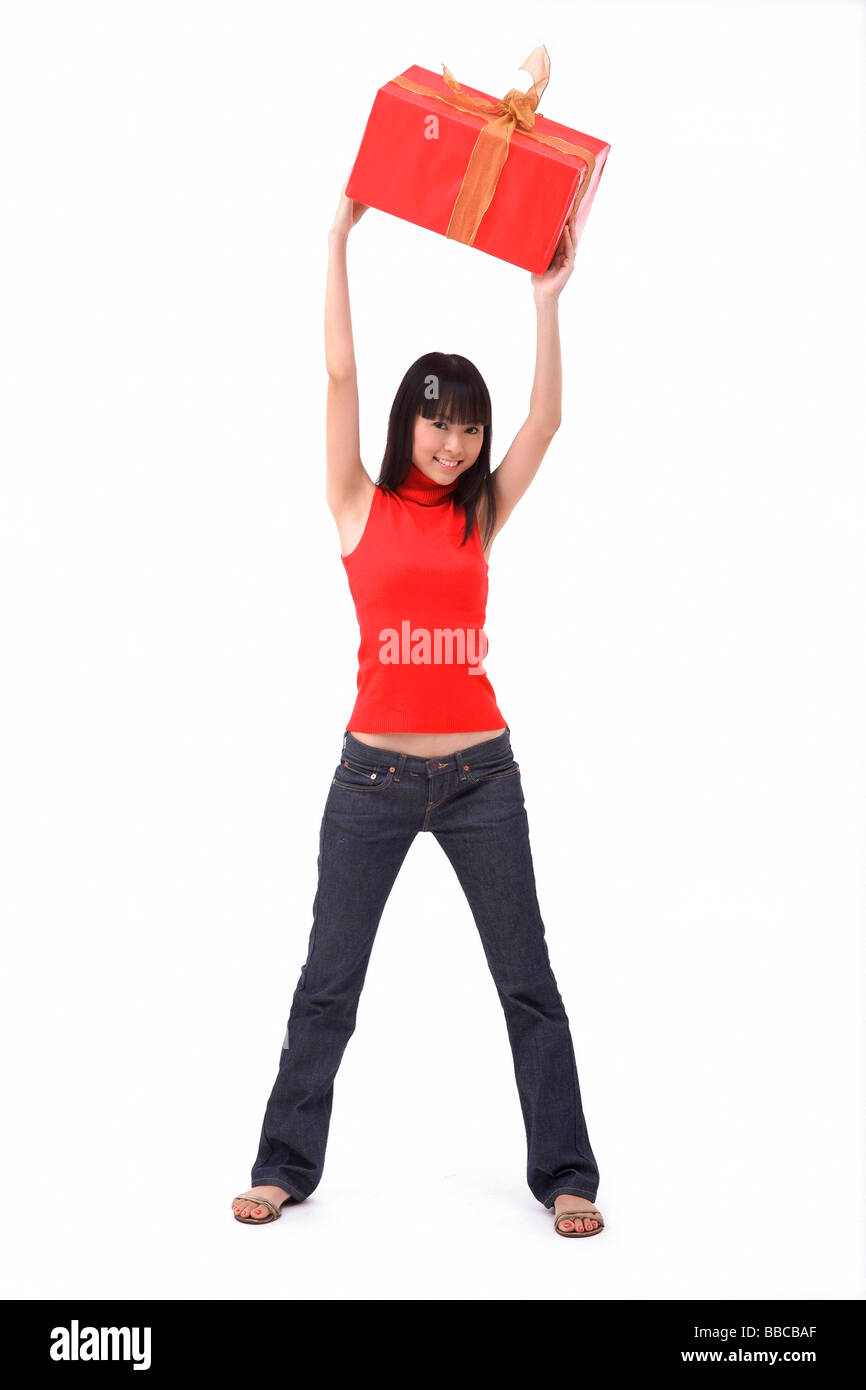 Young woman holding big red gift box over her head Stock Photo - Alamy