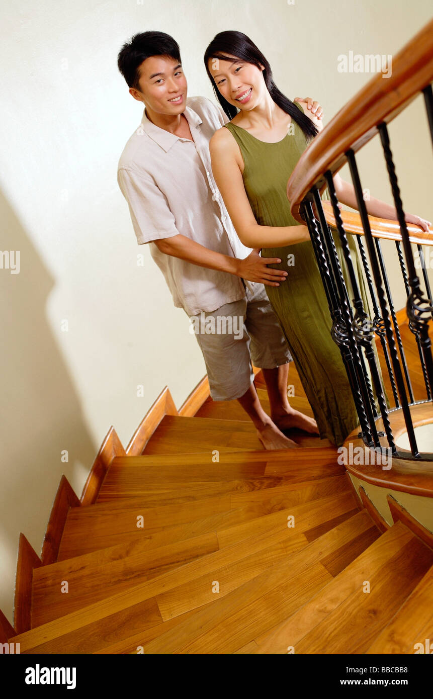 Couple on staircase, smiling at camera Stock Photo - Alamy