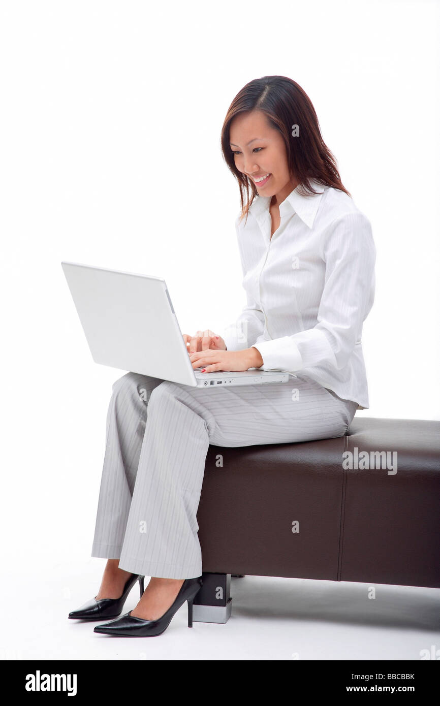Business woman sitting on bench, using laptop Stock Photo - Alamy