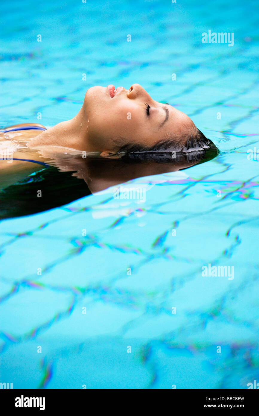 Woman floating in swimming pool Stock Photo - Alamy
