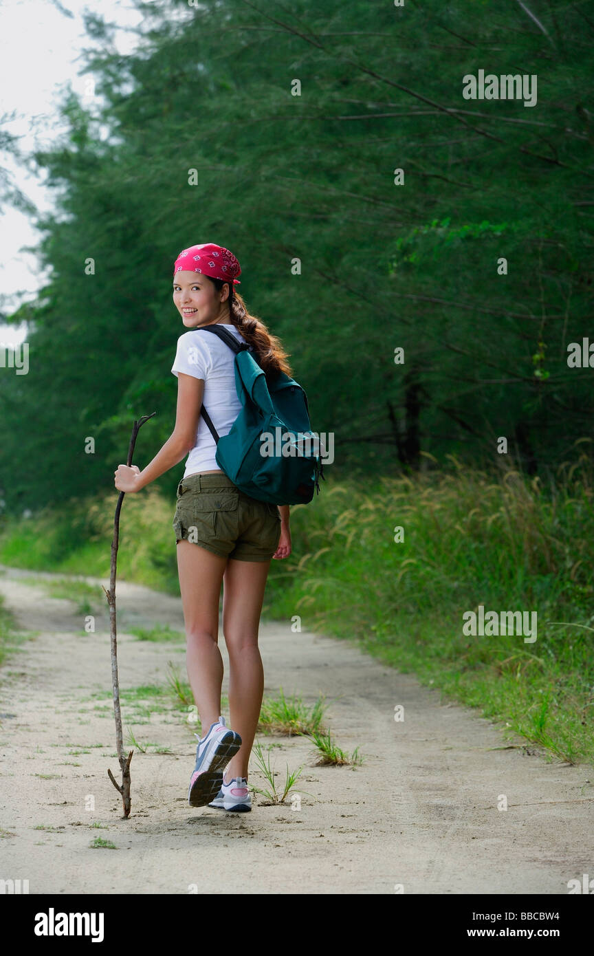 Woman on hiking trail, looking over shoulder at camera Stock Photo - Alamy