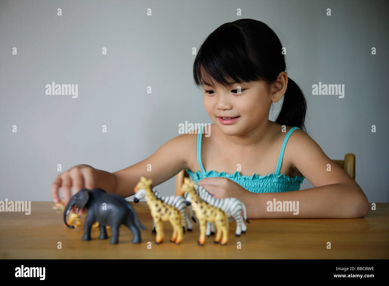 Little girl playing with animals Stock Photo - Alamy