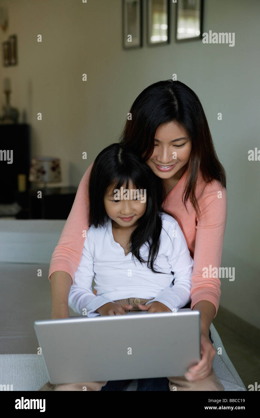 Mother and daughter working at laptop computer Stock Photo - Alamy