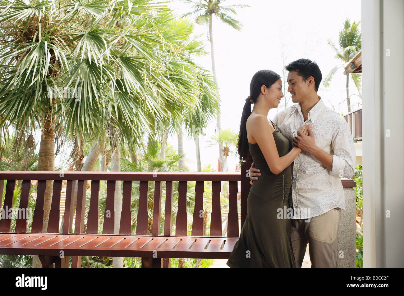 Couple standing face to face, embracing, holding hands Stock Photo - Alamy