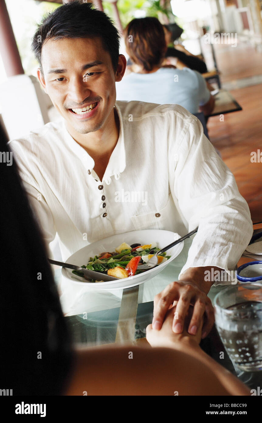 Couple in restaurant, holding hands across the table Stock Photo - Alamy