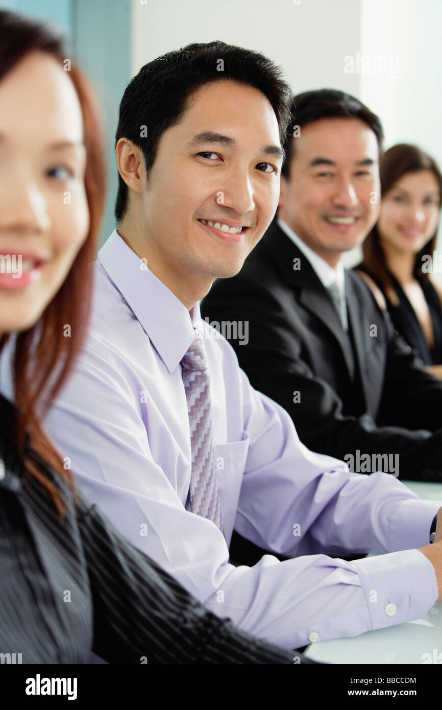 Business people sitting in a row, smiling at camera Stock Photo - Alamy