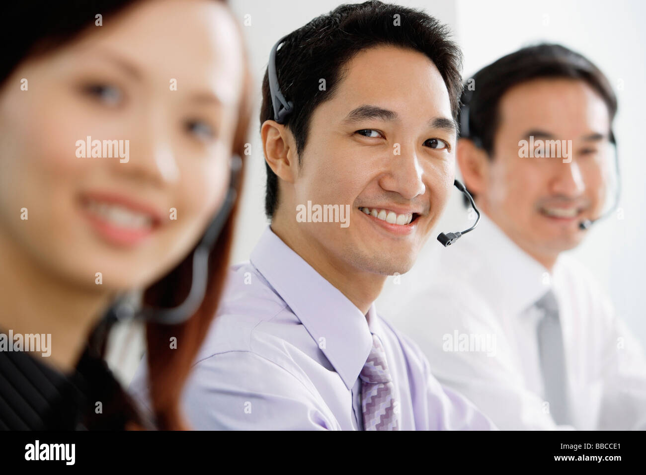 Executives wearing headsets, smiling at camera Stock Photo - Alamy