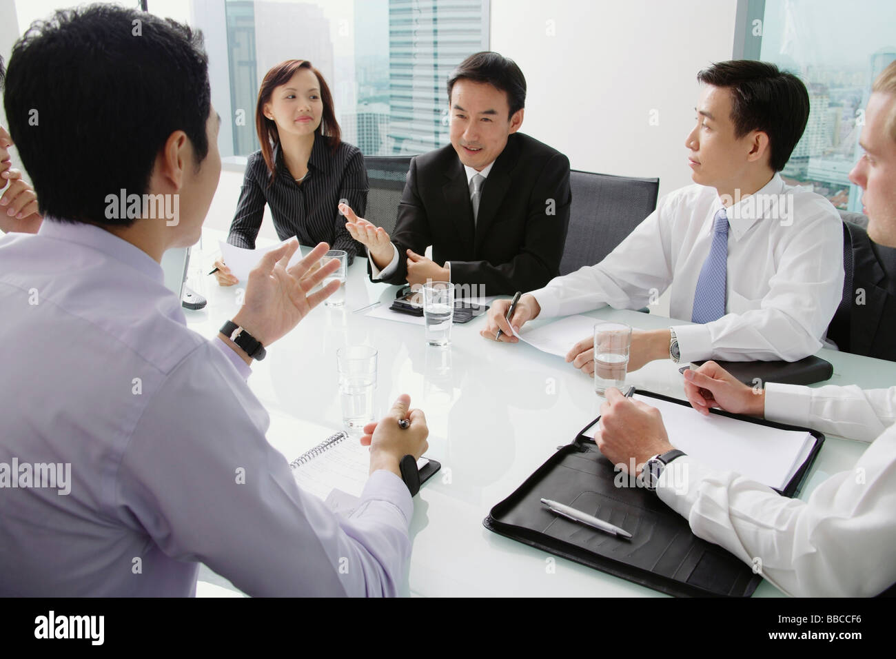 Executives having a discussion around conference table Stock Photo - Alamy