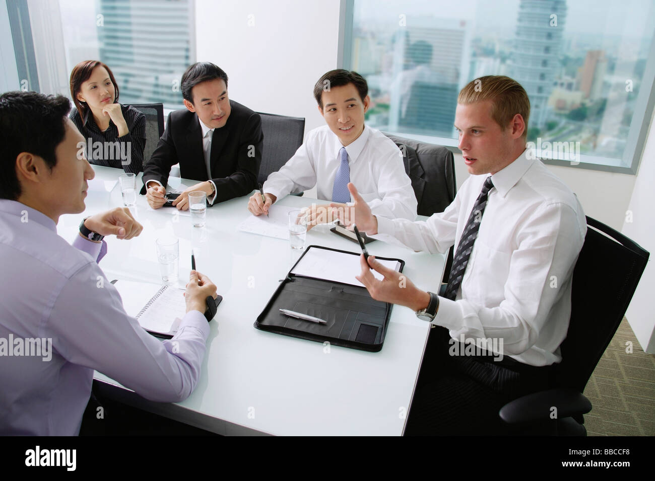 Executives having a discussion around conference table, Caucasian man ...