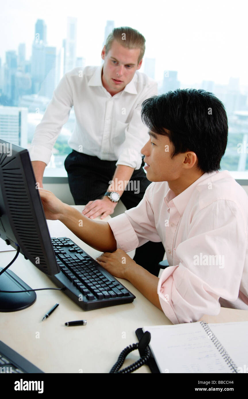Male executives in office, looking at computer Stock Photo - Alamy