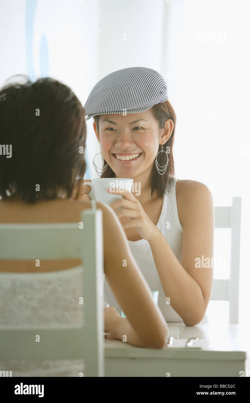 Young women in cafe, having coffee, sitting face to face Stock Photo ...