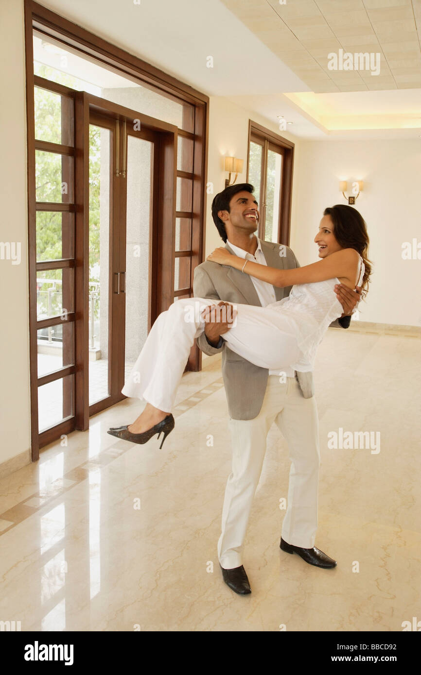 Man carrying woman over threshold Stock Photo - Alamy