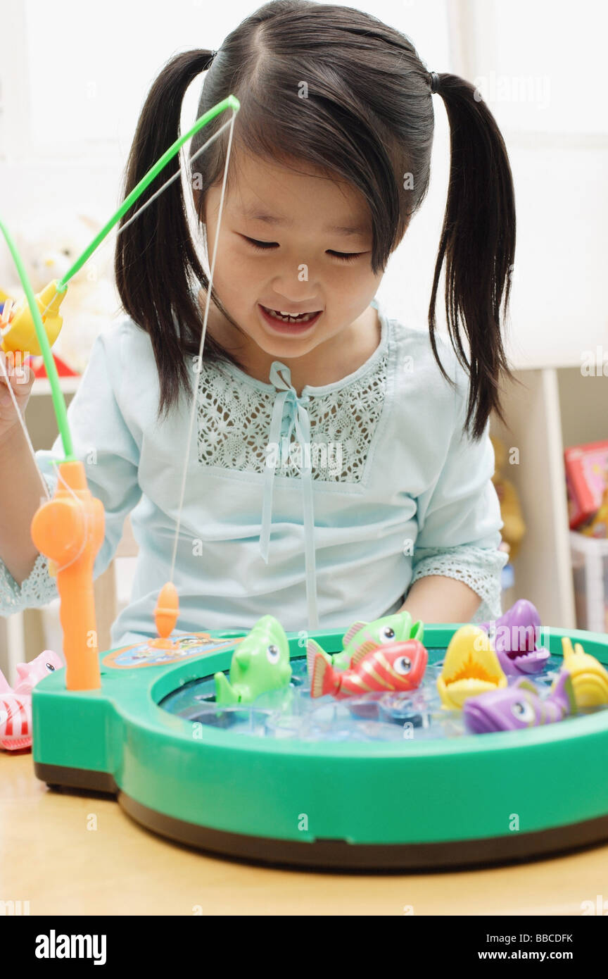 Girl playing with fishing game Stock Photo - Alamy
