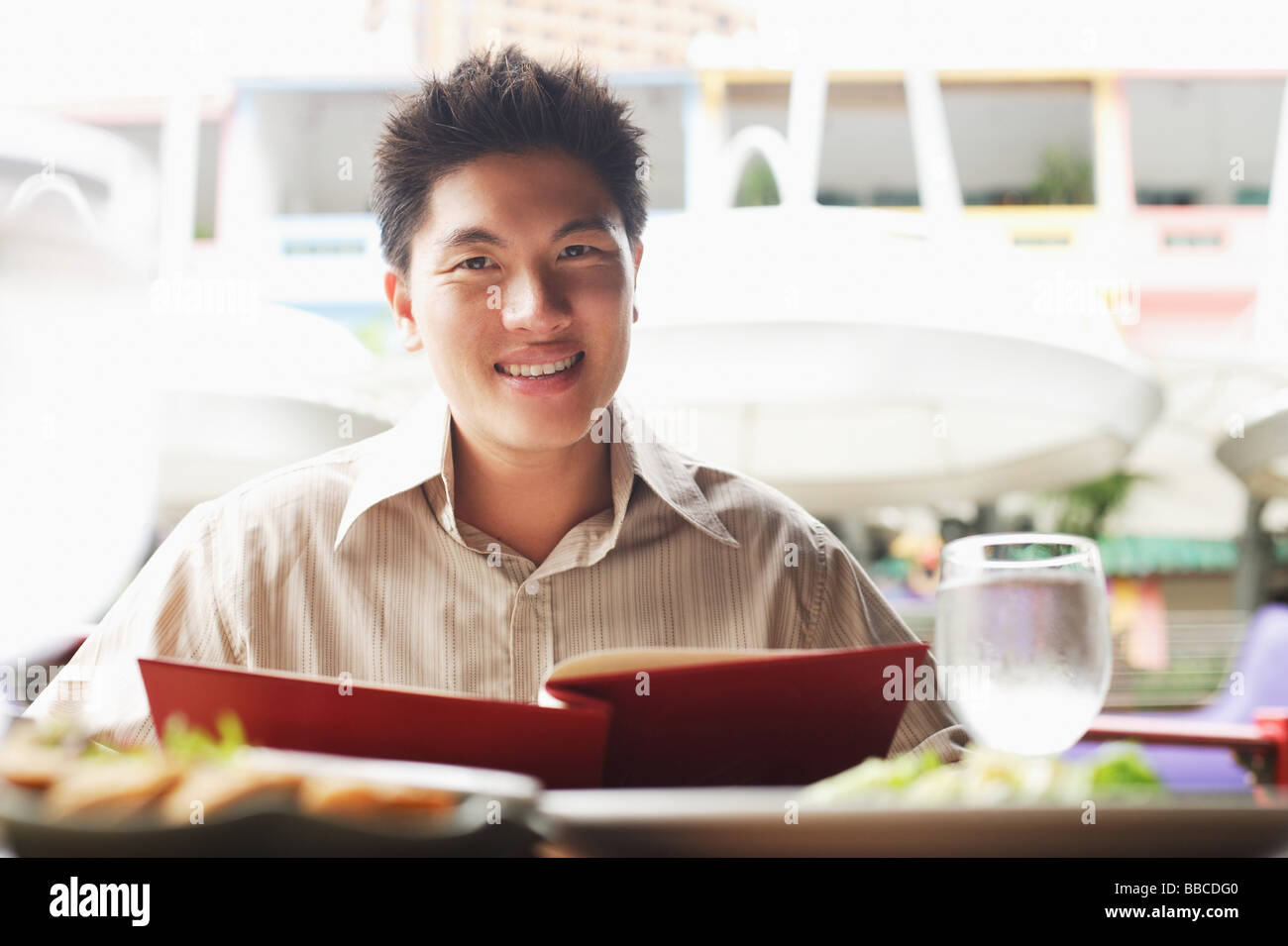 Man in cafe, holding menu, looking at camera Stock Photo - Alamy