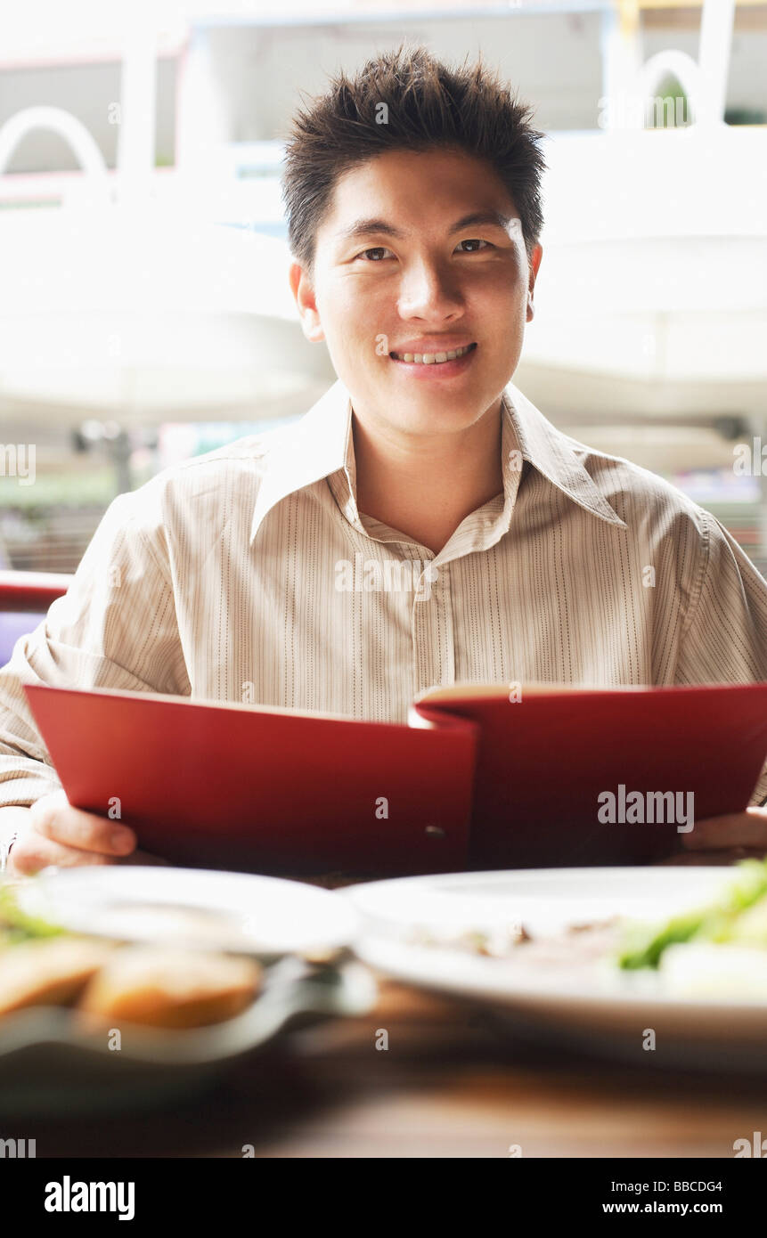 Man holding menu, looking at camera Stock Photo - Alamy