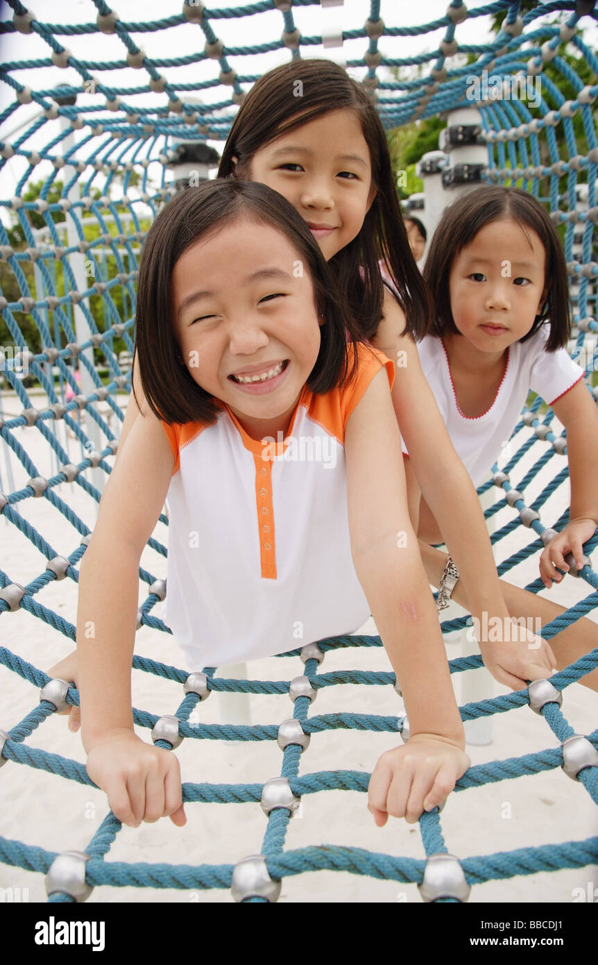 Girls at playground, crawling through net tunnel Stock Photo - Alamy