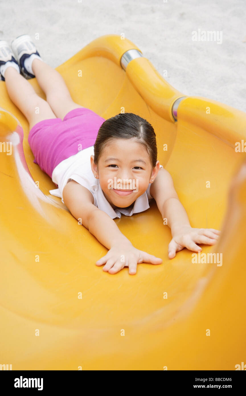 Girl on slide, smiling at camera Stock Photo - Alamy