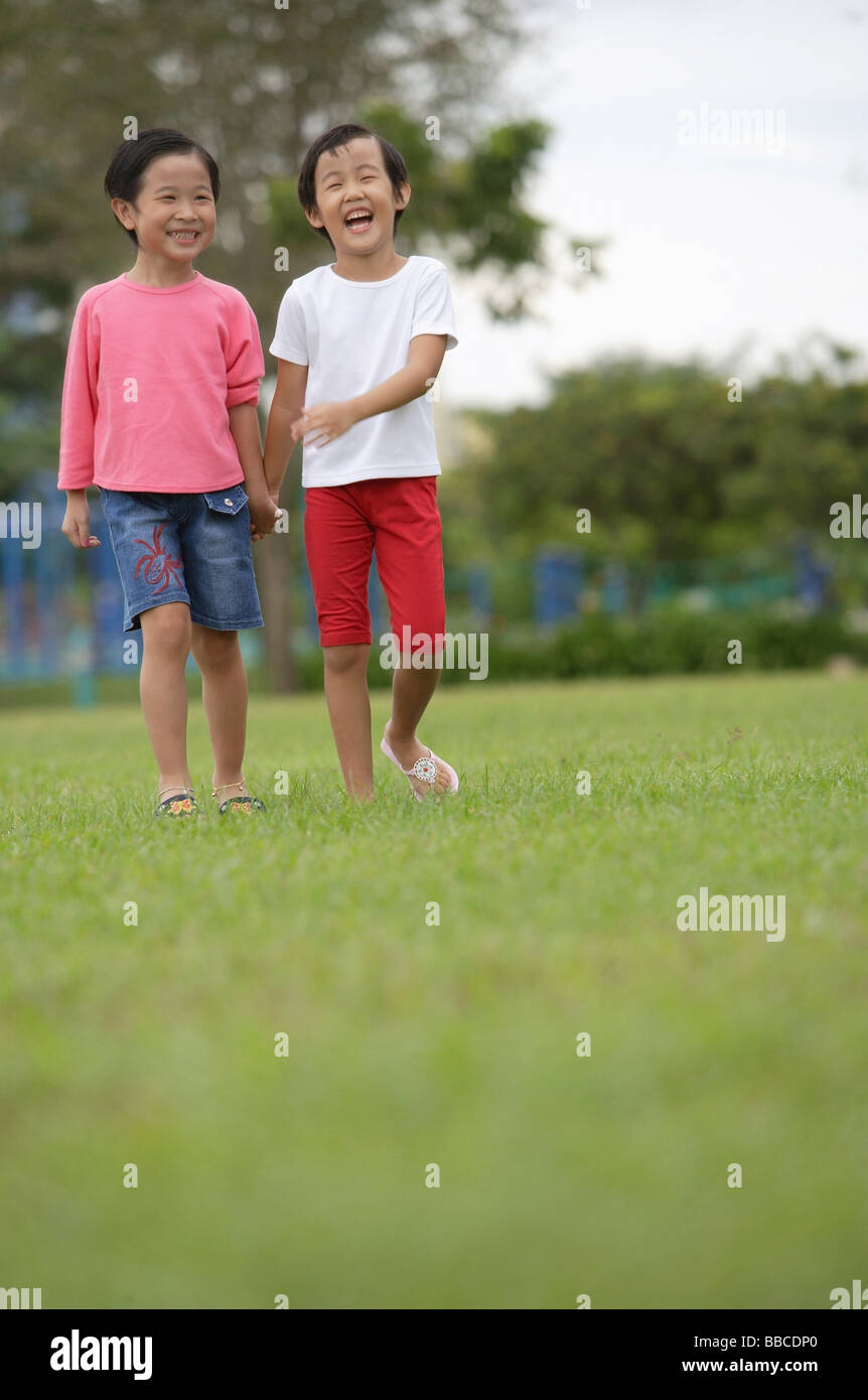 Two girls walking in park Stock Photo - Alamy