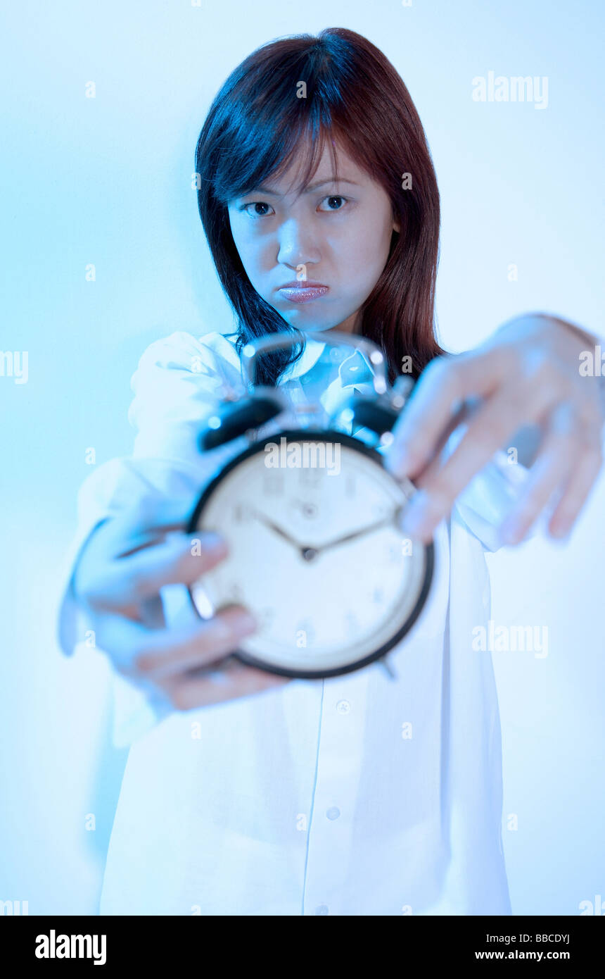 Woman holding clock looking camera hi-res stock photography and images ...