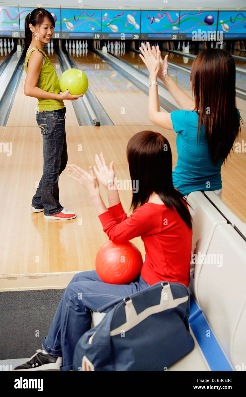 Women in bowling alley, cheering friend on Stock Photo - Alamy
