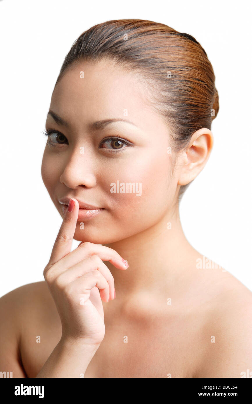 Young woman, finger on mouth Stock Photo - Alamy