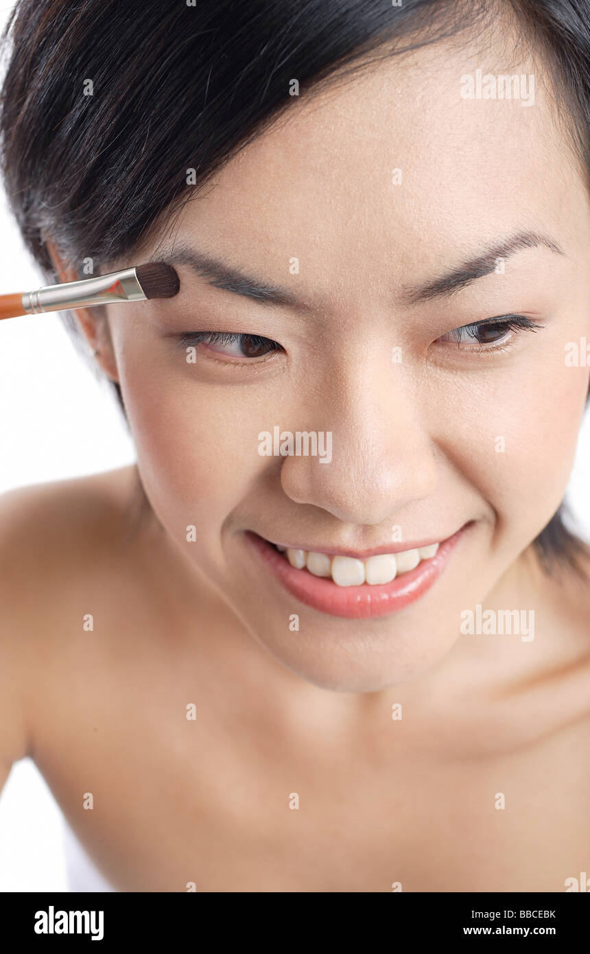 Woman applying eyeshadow Stock Photo - Alamy