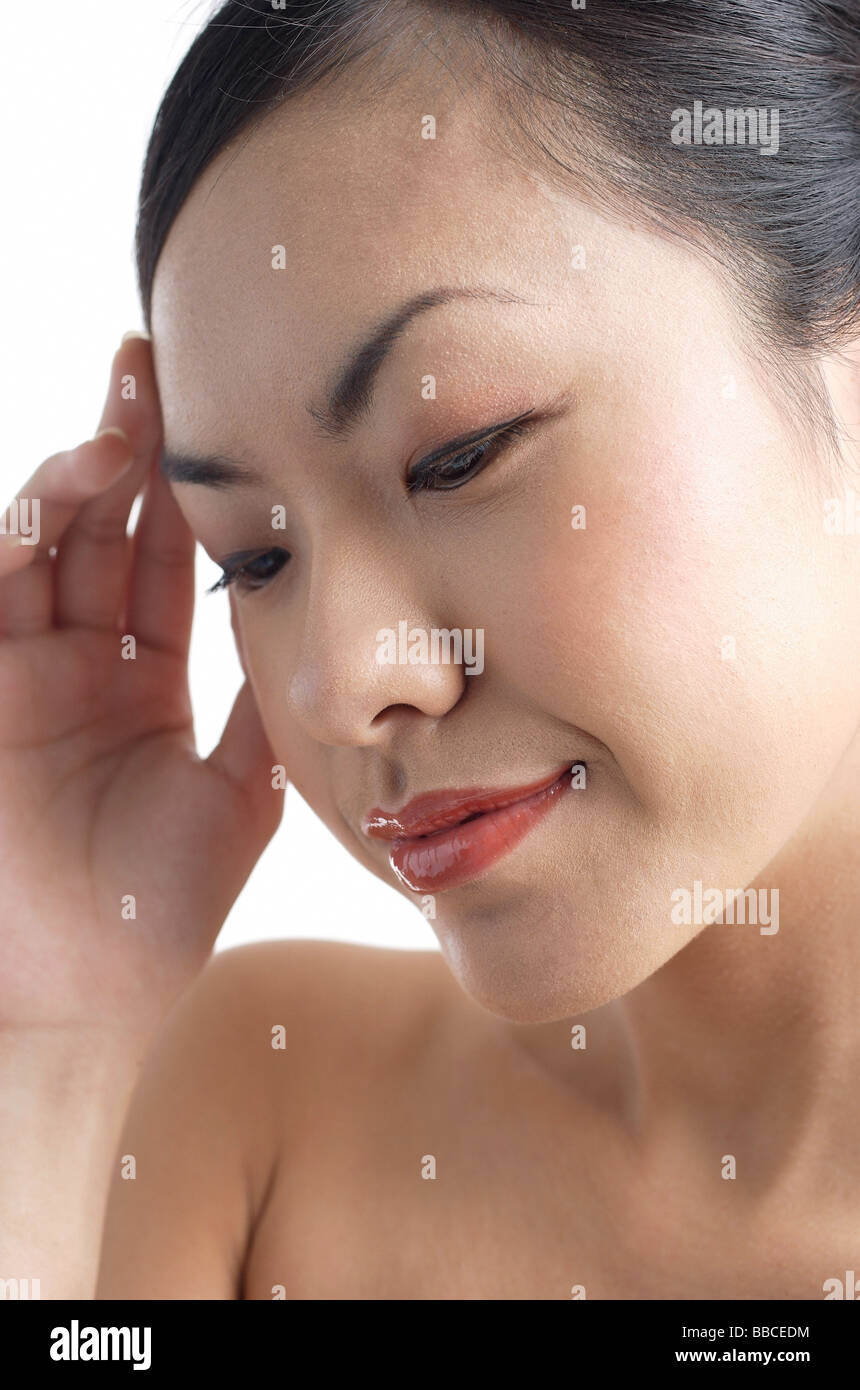 Woman looking down, hand on head Stock Photo - Alamy