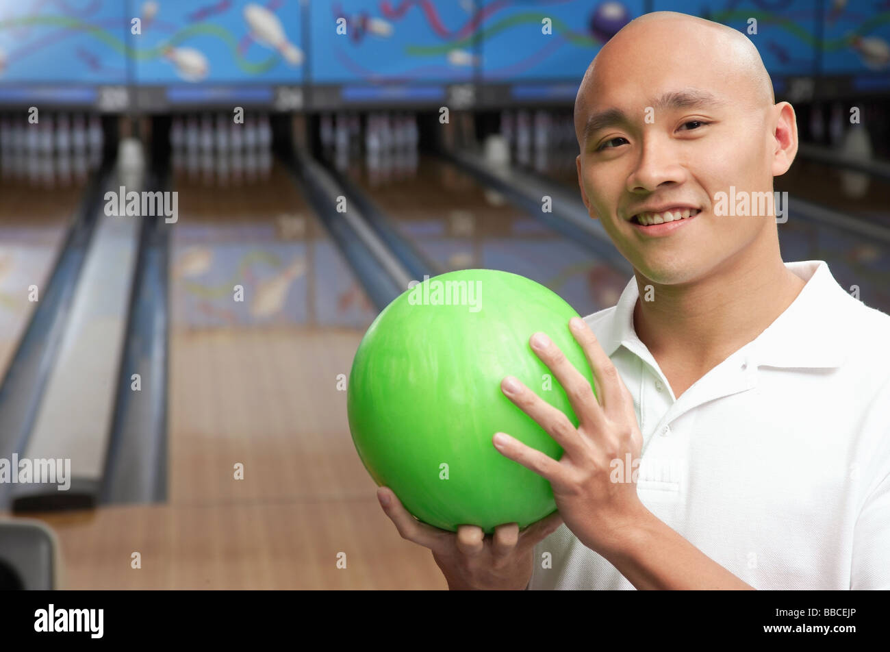 Man holding bowling ball, looking at camera Stock Photo - Alamy
