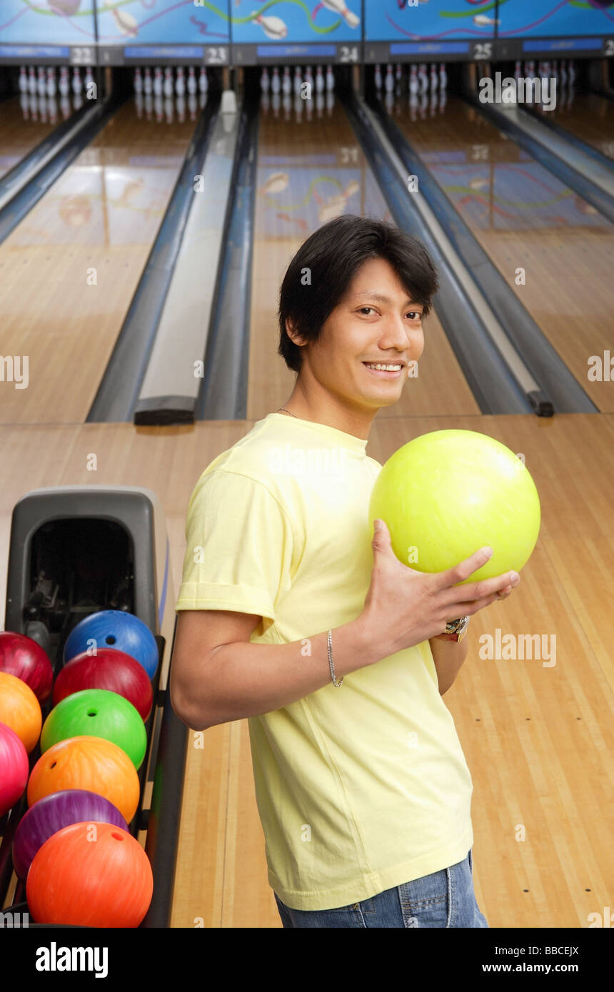 Man with bowling ball, looking at camera Stock Photo - Alamy