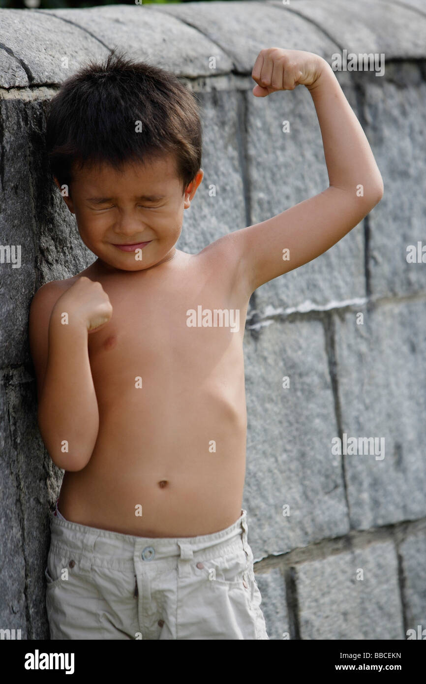 Boy flexing his muscles Stock Photo - Alamy