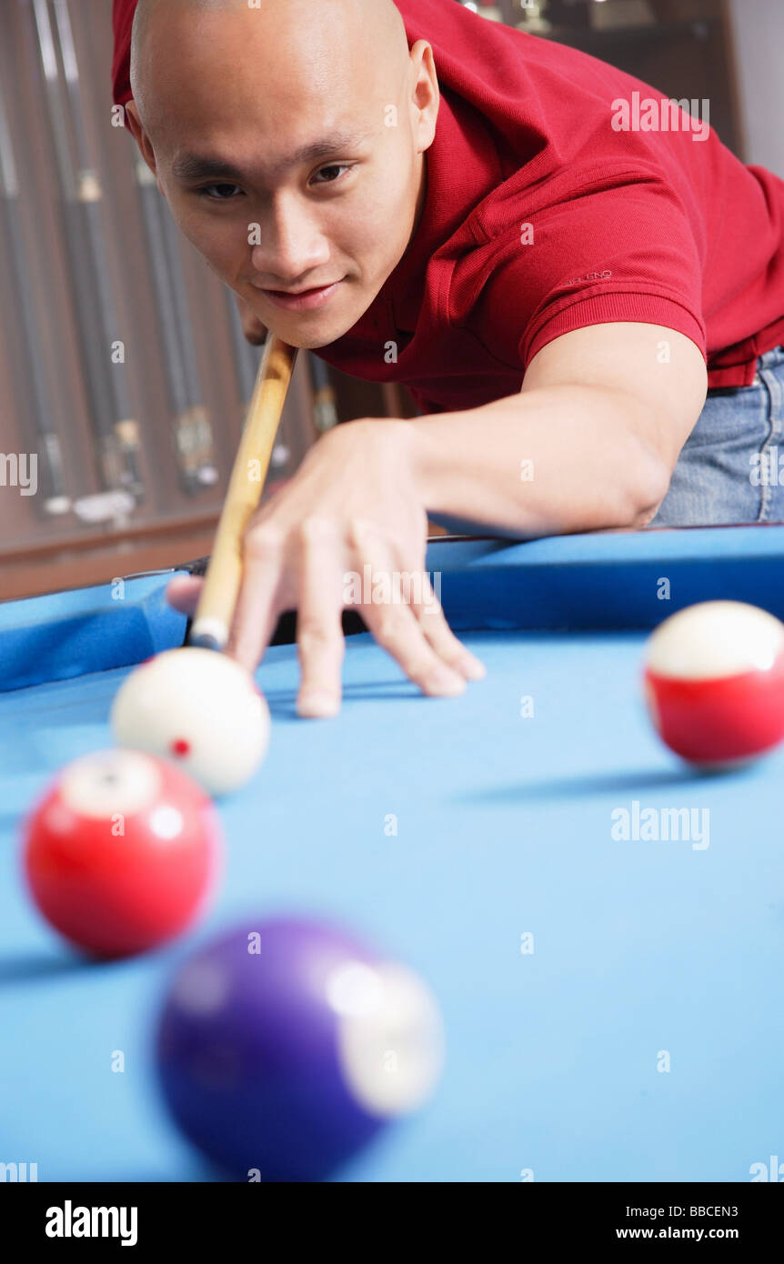 Man holding pool cue, aiming at ball Stock Photo - Alamy